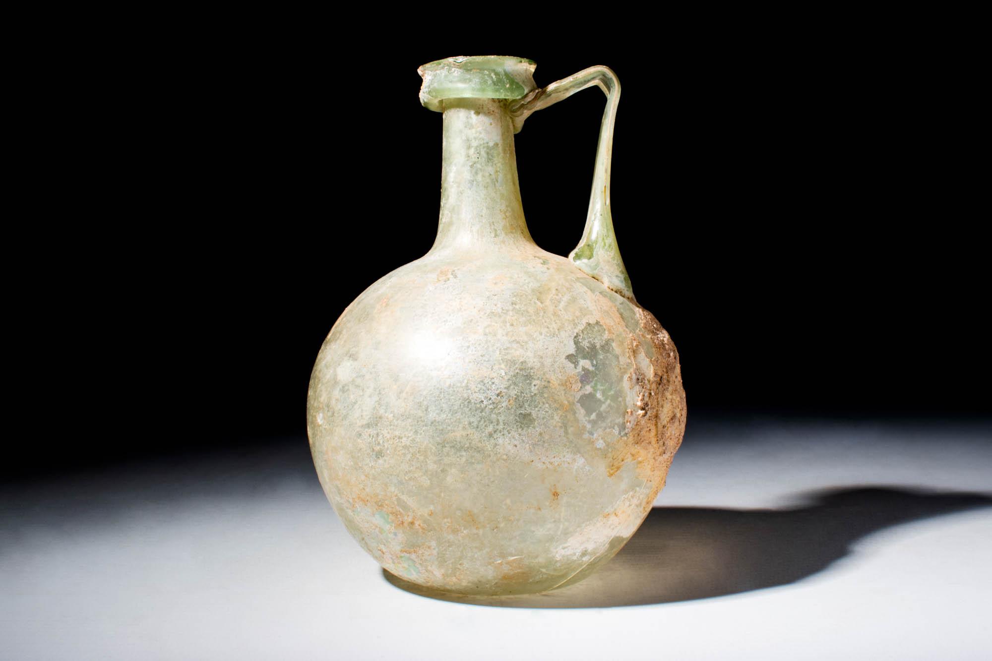 At Auction: ROMAN GLASS JUG WITH ELEGANT VERTICAL HANDLE